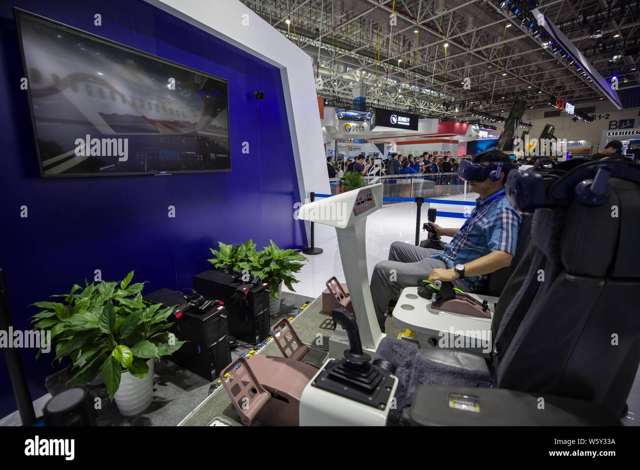 A visitor tries out a simulator of the CR929 widebody passenger jet ...