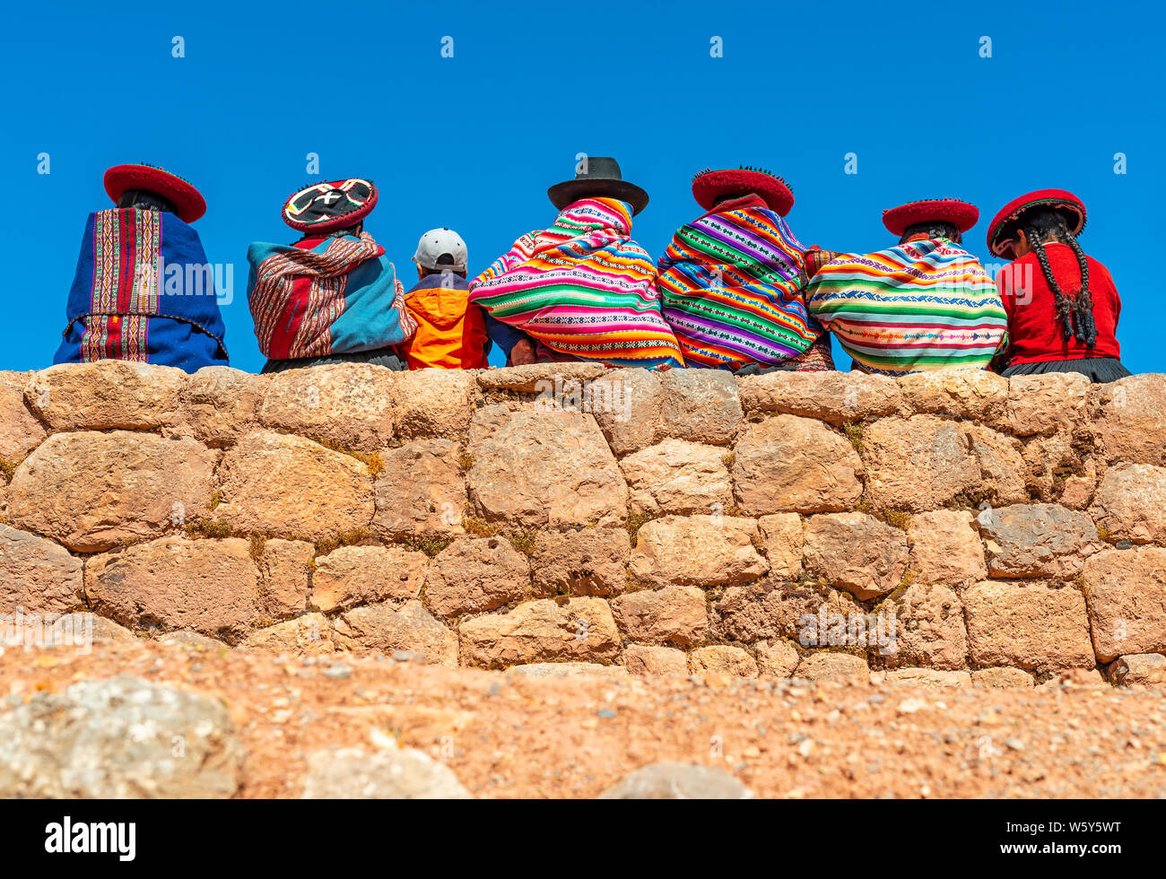 Quechua indigenous women in traditional clothing with a boy sitting on ...