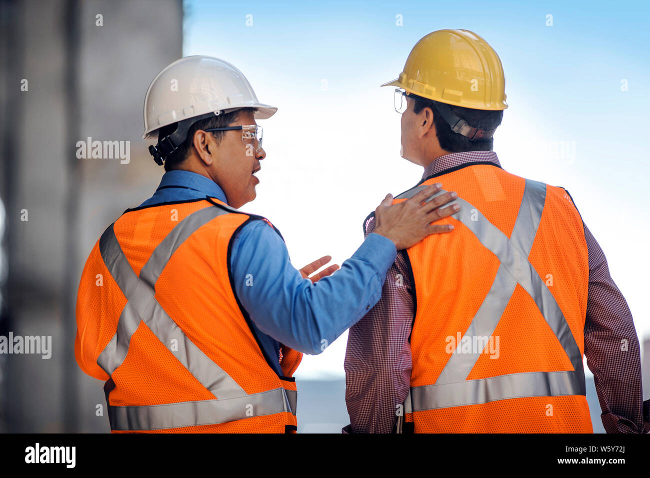 Workers at construction site discuss progress Stock Photo - Alamy