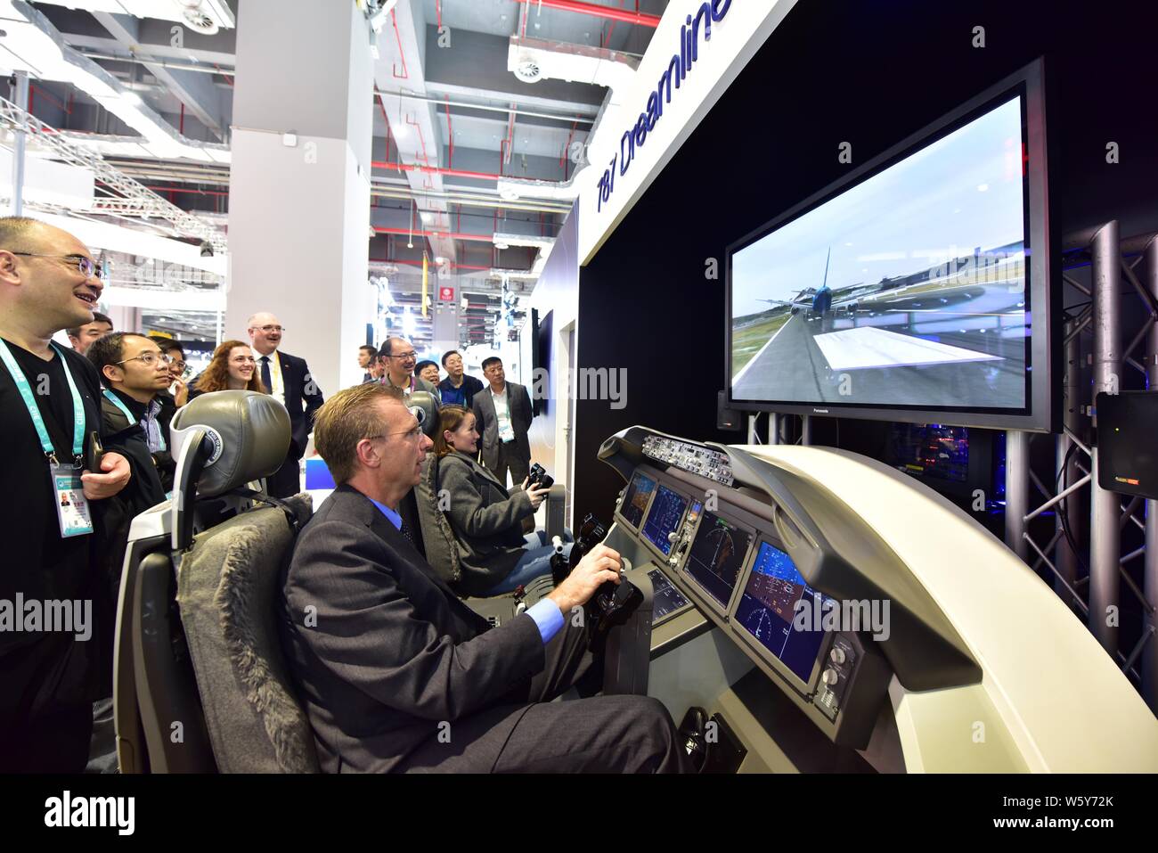 Visitors experience the real full flight cockpit simulator at the stand ...