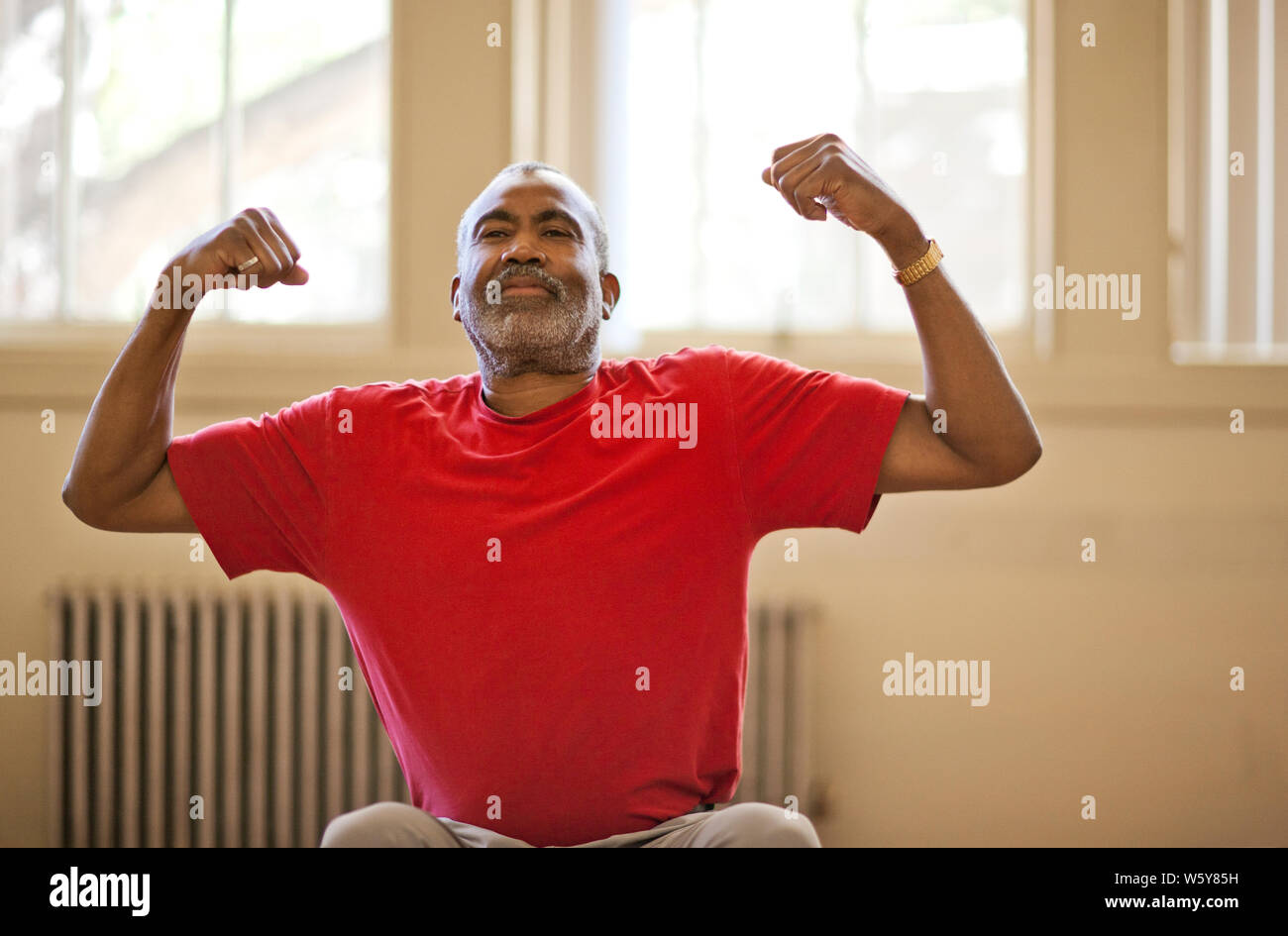 Portrait of a smiling senior man flexing his muscles Stock Photo - Alamy