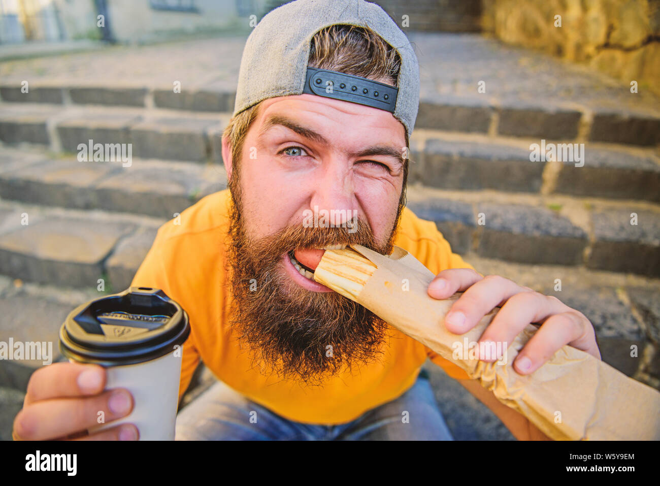 Eating fast. Bearded man eating unhealthy hotdog sandwich. Caucasian ... Eating fast. Bearded man eating unhealthy hotdog sandwich. Caucasian ...