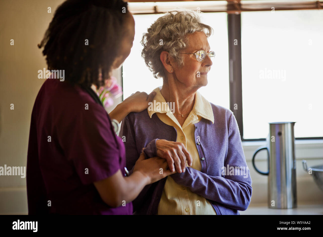 Young nurse comforting a grieving senior woman Stock Photo - Alamy