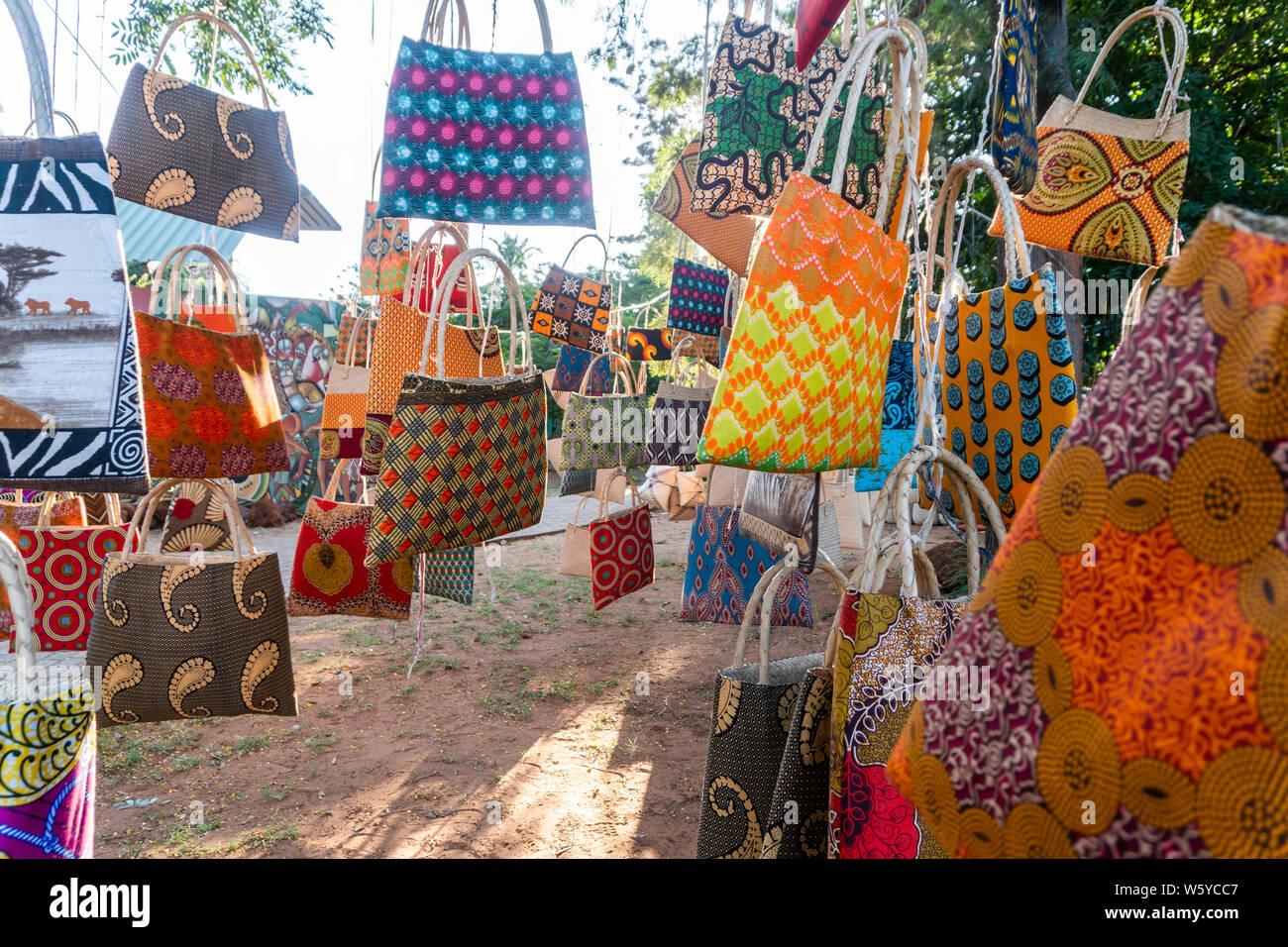 Traditional african market selling colorful bags hanged on trees, FEIMA ...