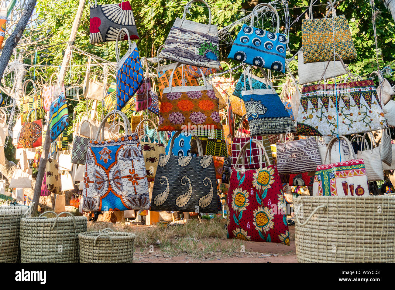 Traditional African market selling colorful bags hanged on trees, FEIMA ...
