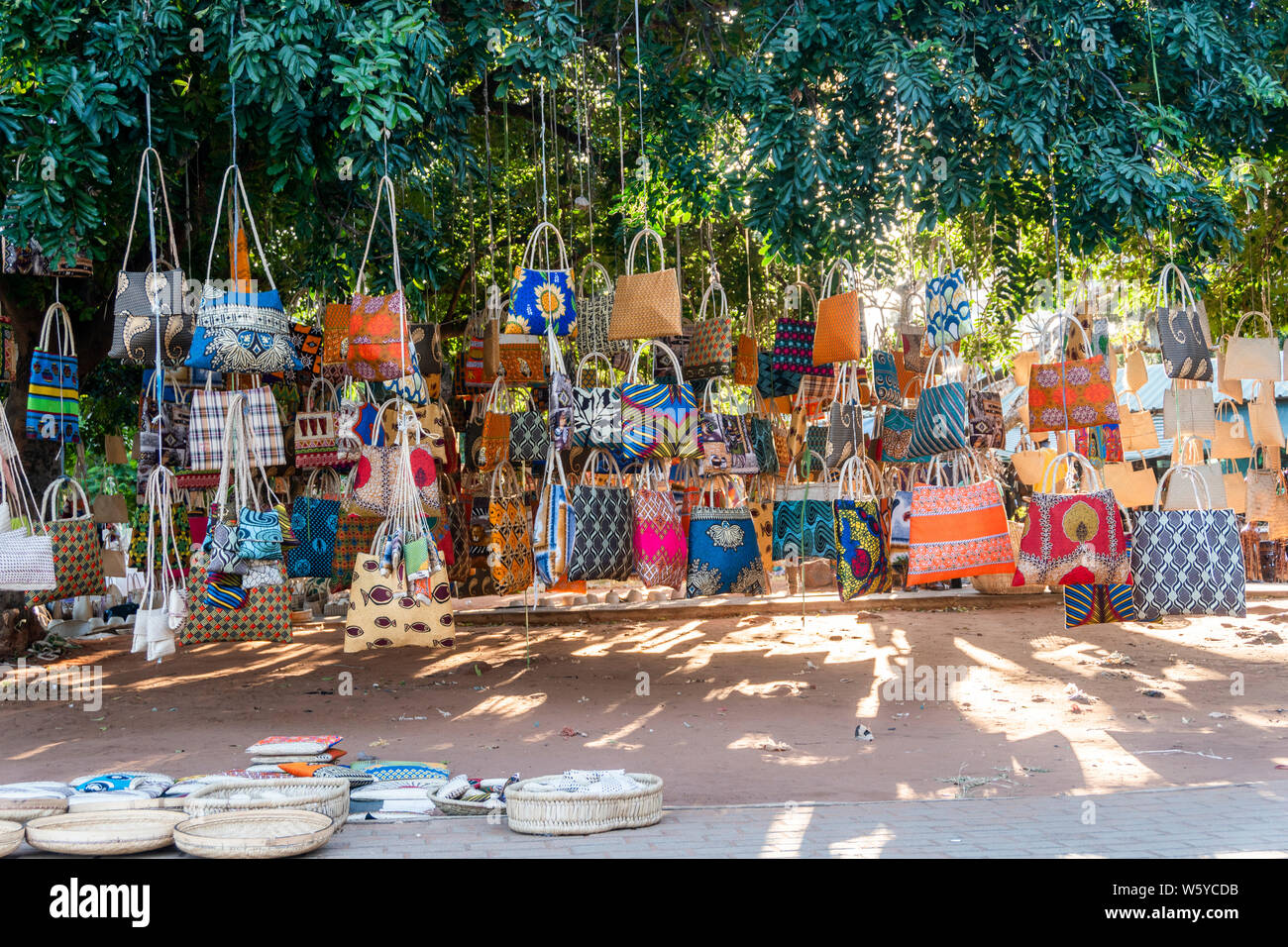 Traditional African market selling colorful bags hanged on trees, FEIMA ...