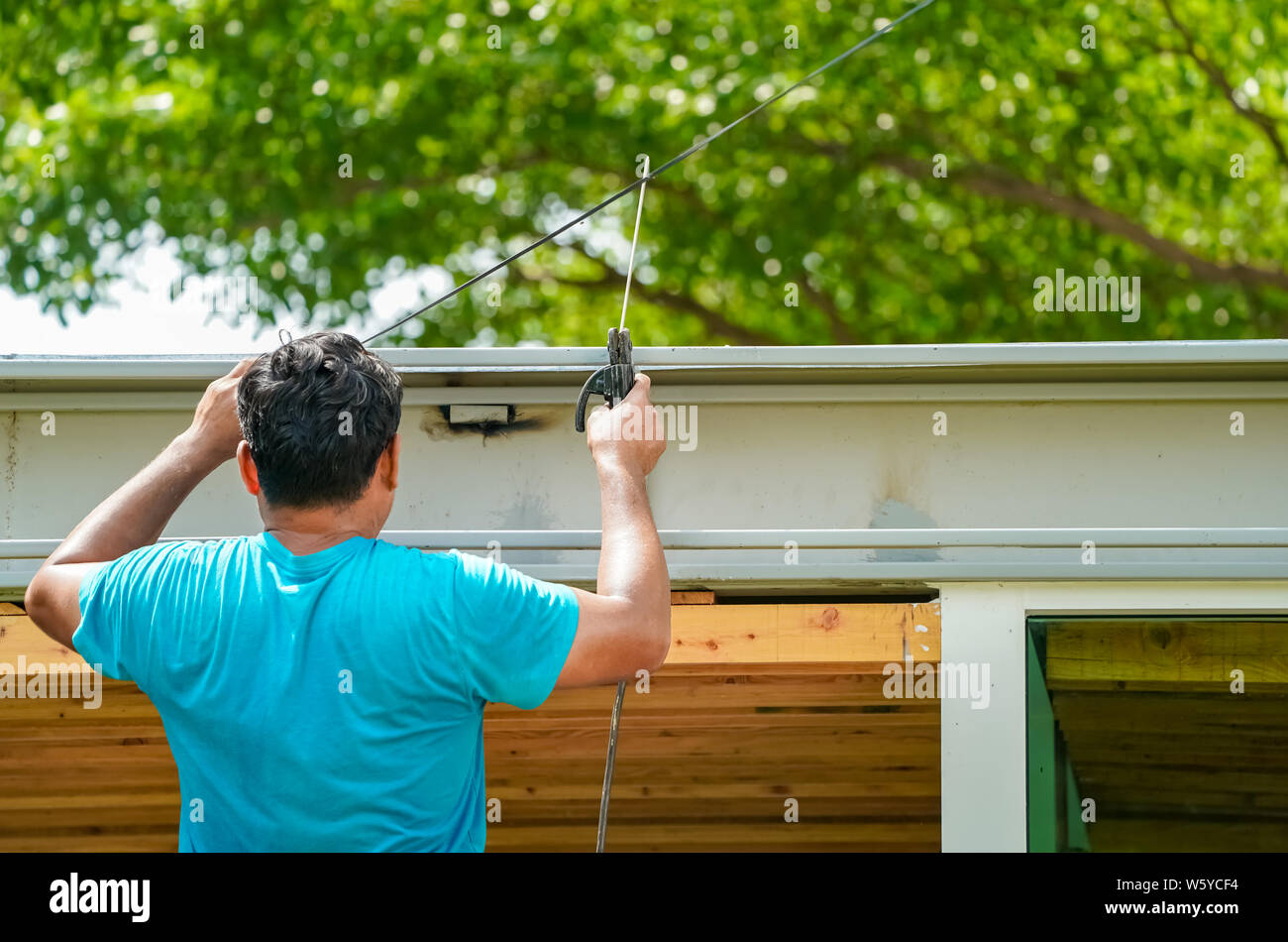 Asian worker welds the steel stick to create a structure for roof water ...
