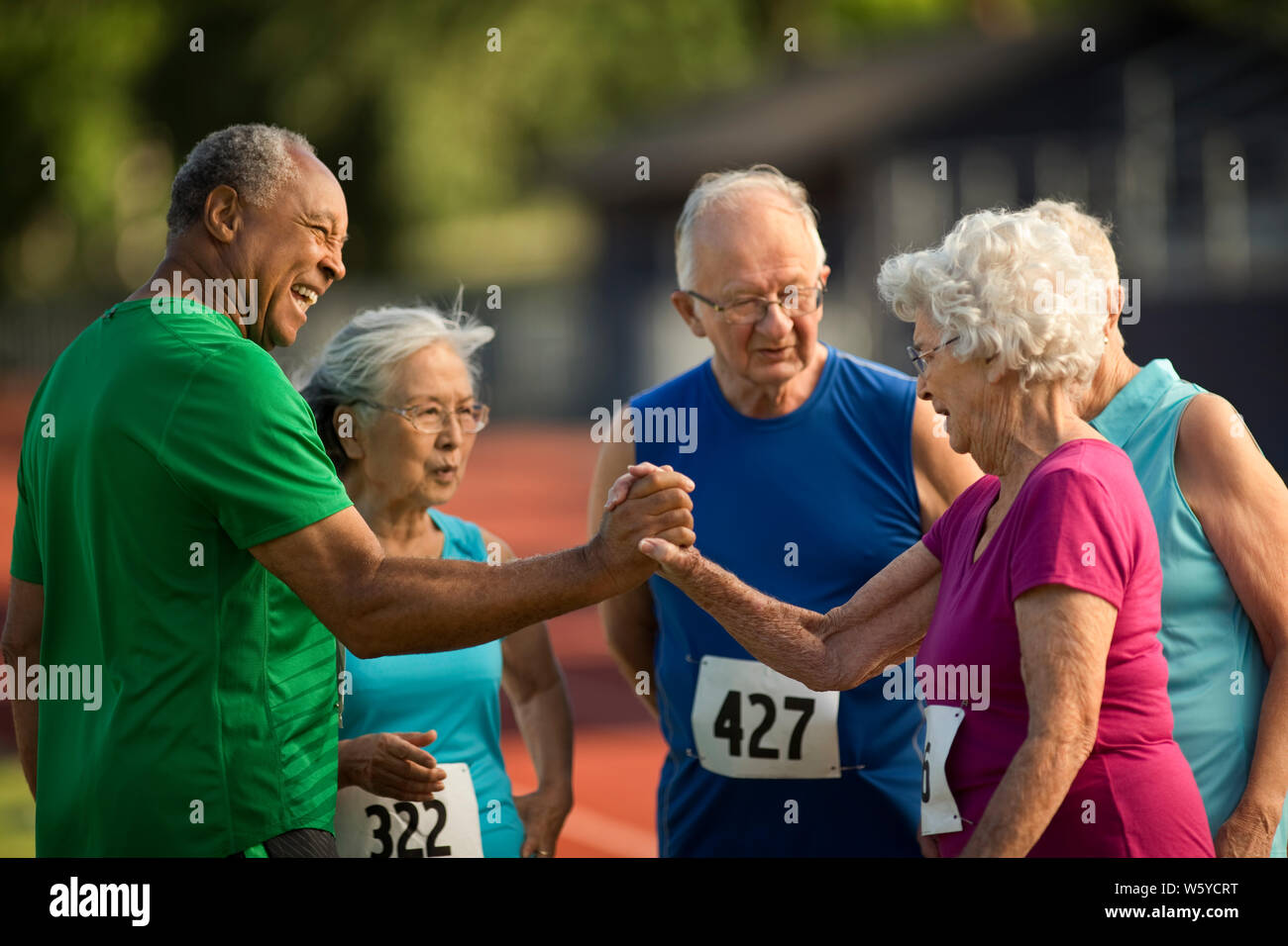 Happy seniors playfully challenge one another before an athletics event ...