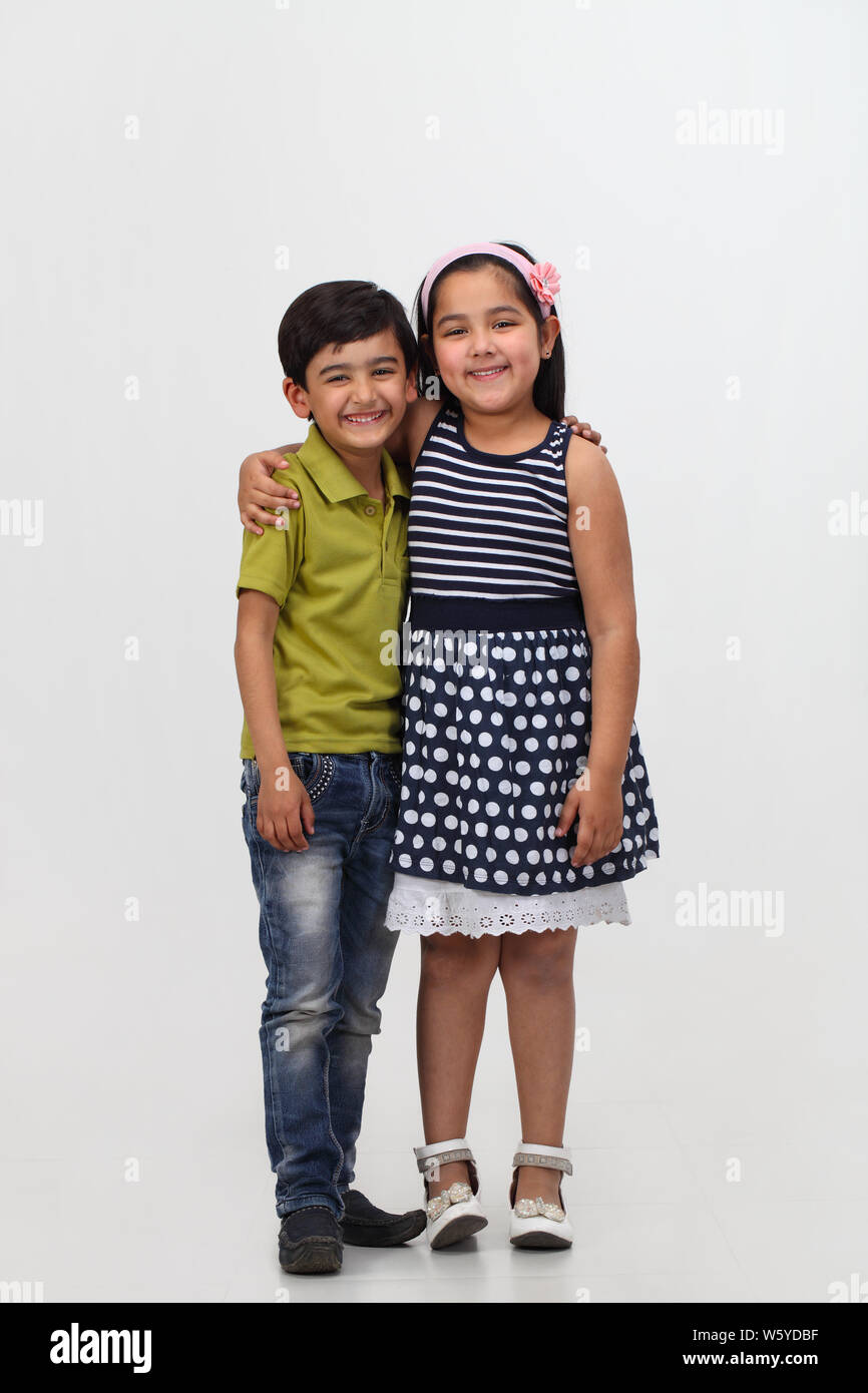 Portrait of two children standing together smiling Stock Photo - Alamy