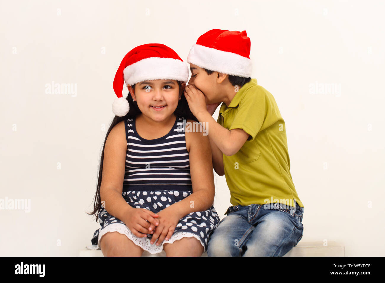 Children whispering friends ears hi-res stock photography and images ...