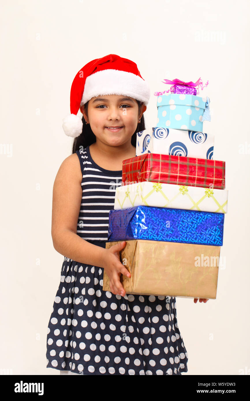 Girl holding stack of gifts and smiling Stock Photo - Alamy