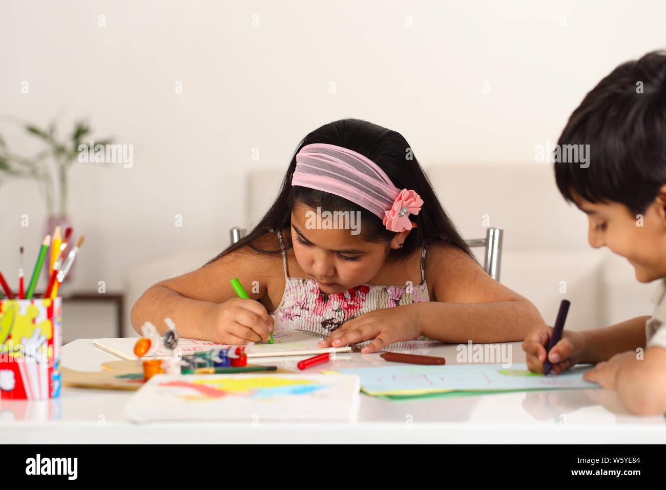 Two children drawing together at home Stock Photo - Alamy