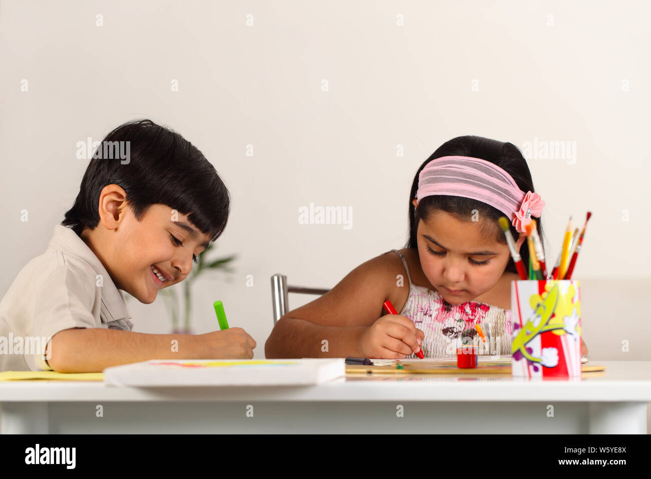 Two children drawing together at home Stock Photo - Alamy