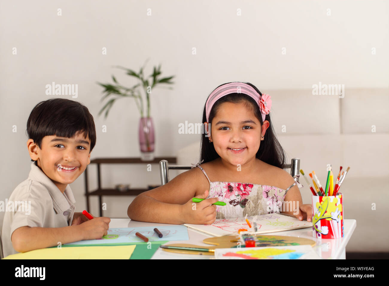 Two children drawing together at home Stock Photo - Alamy