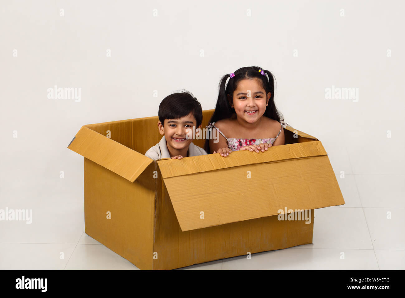 Children playing in a cardboard box Stock Photo - Alamy