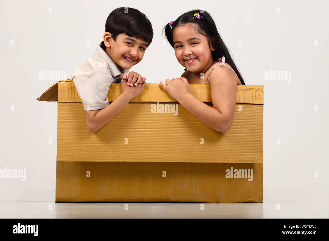 Children playing in a cardboard box Stock Photo - Alamy