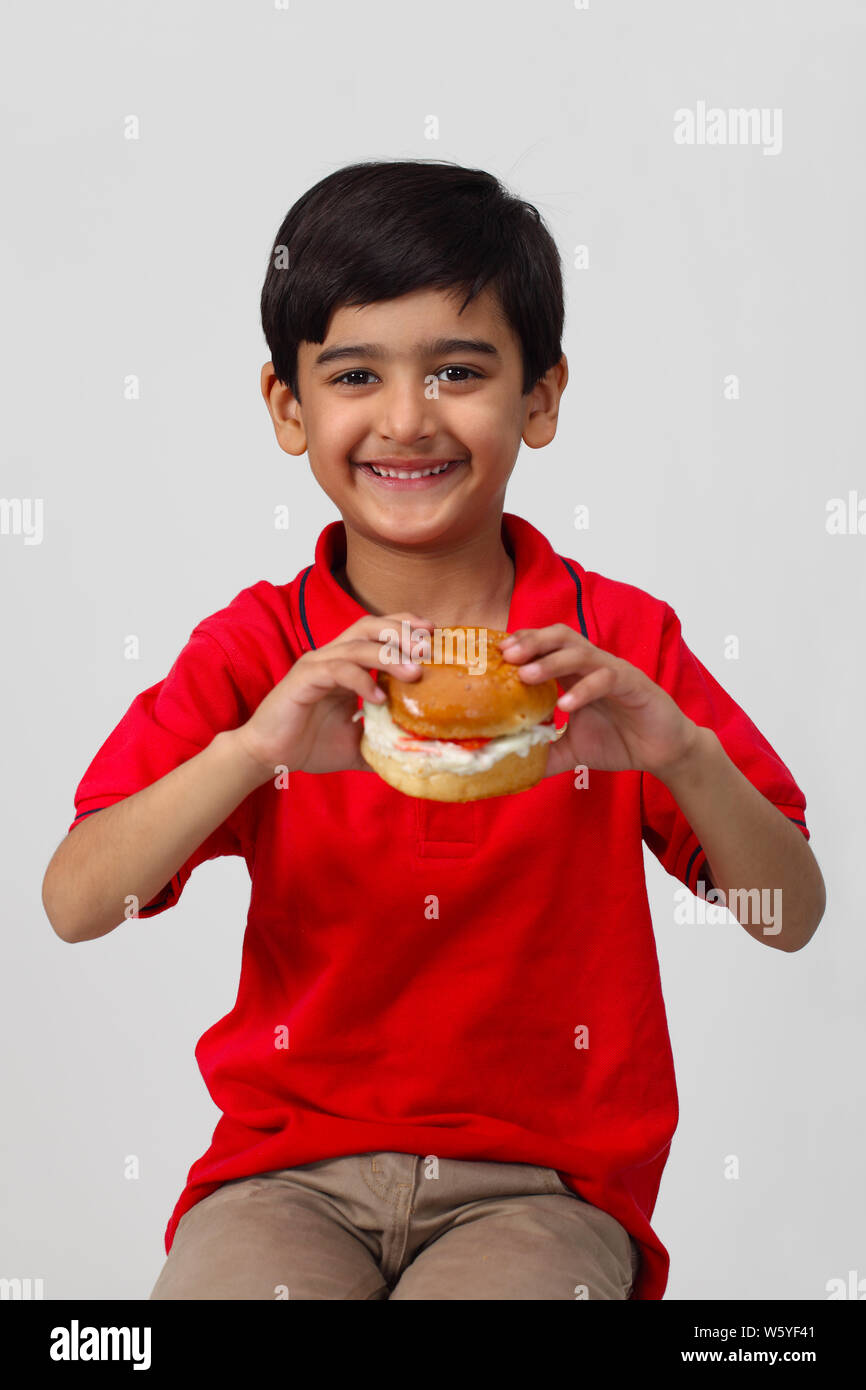 Boy eating a burger Stock Photo - Alamy