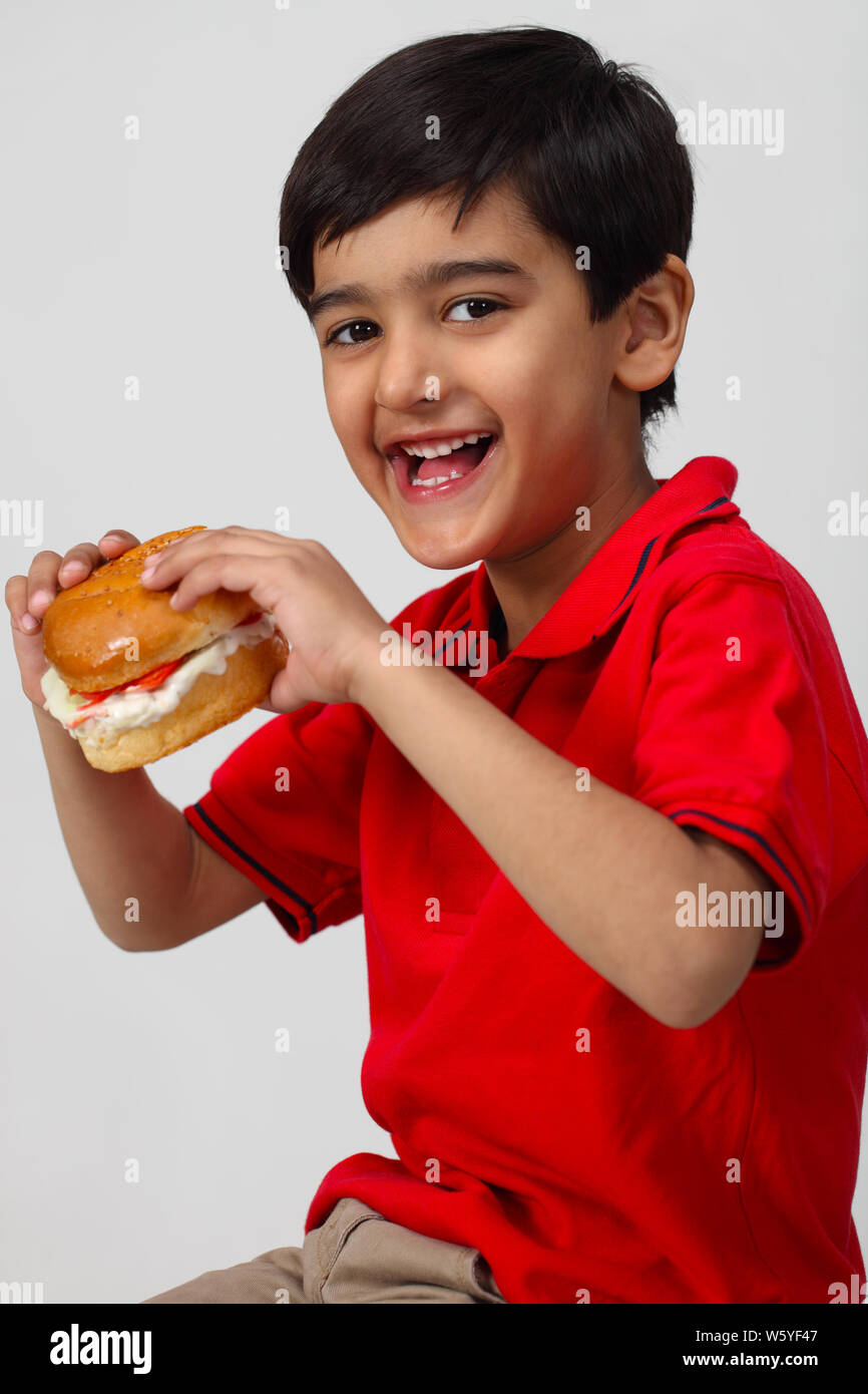 Boy eating a burger Stock Photo - Alamy