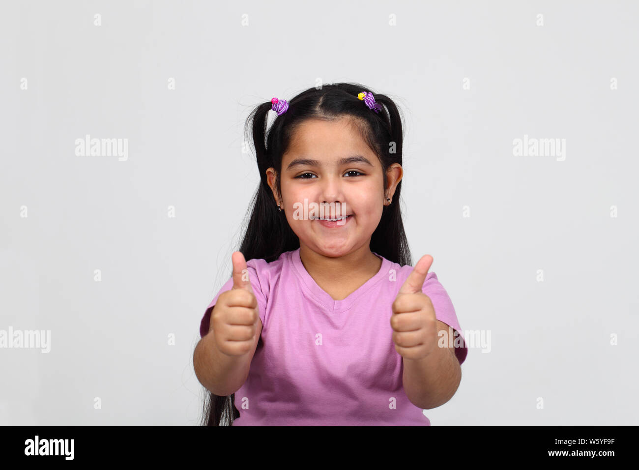 Portrait of a girl showing thumbs up with both hands Stock Photo - Alamy