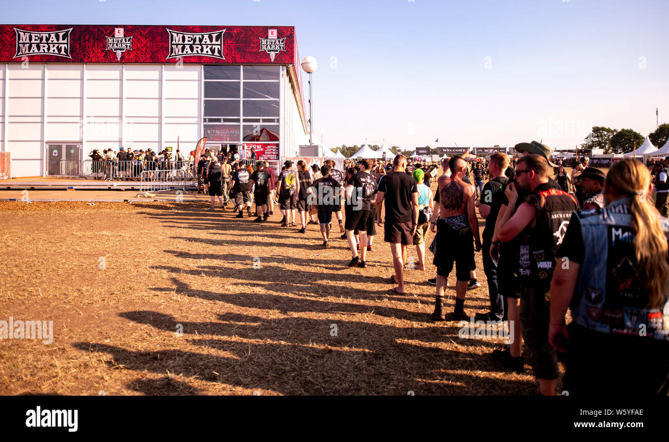 Wacken, Germany. 30th July, 2019. Visitors of the Wacken Festival wait ...