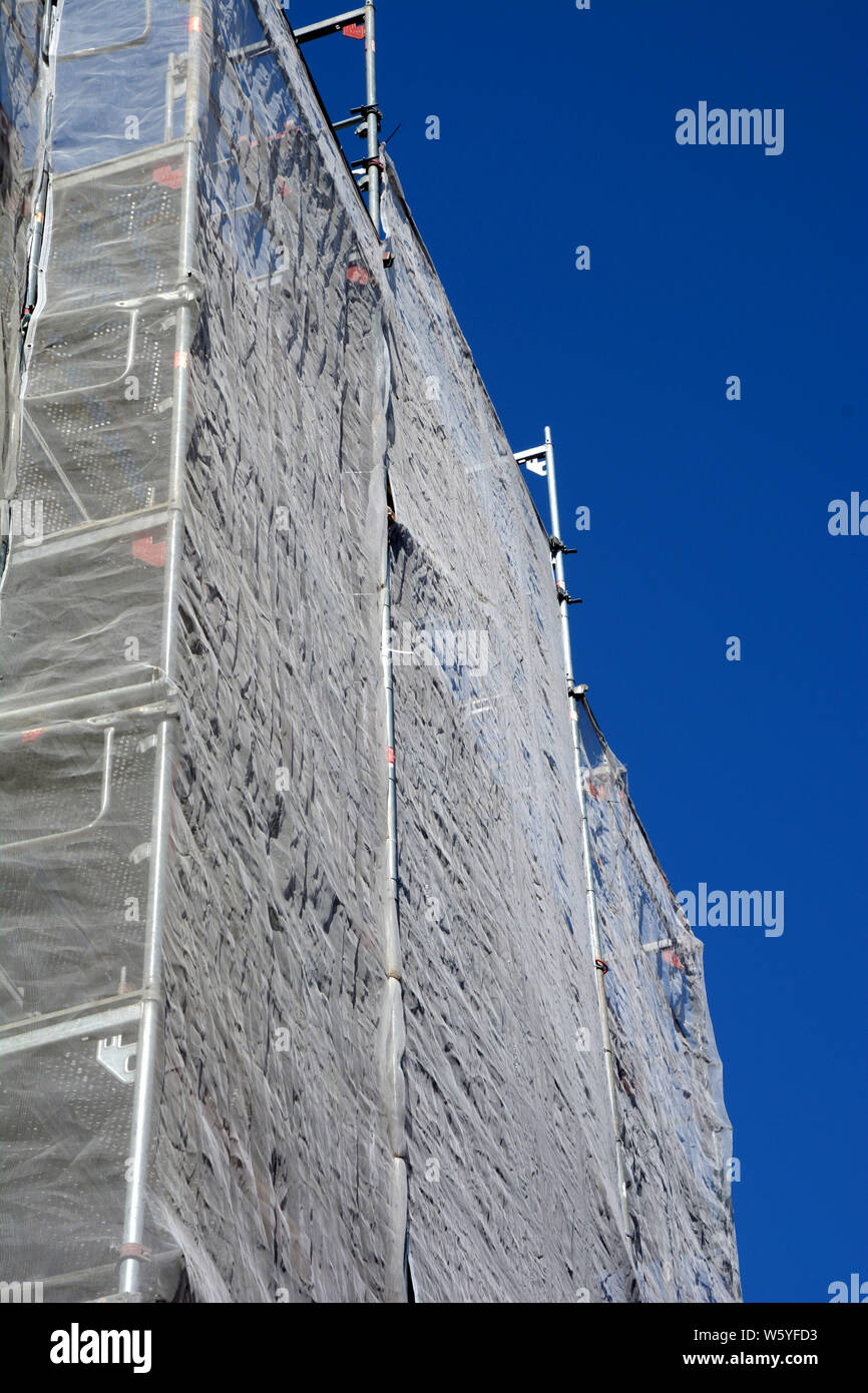 renovation house facade, protection grid and scaffolding covered old ...