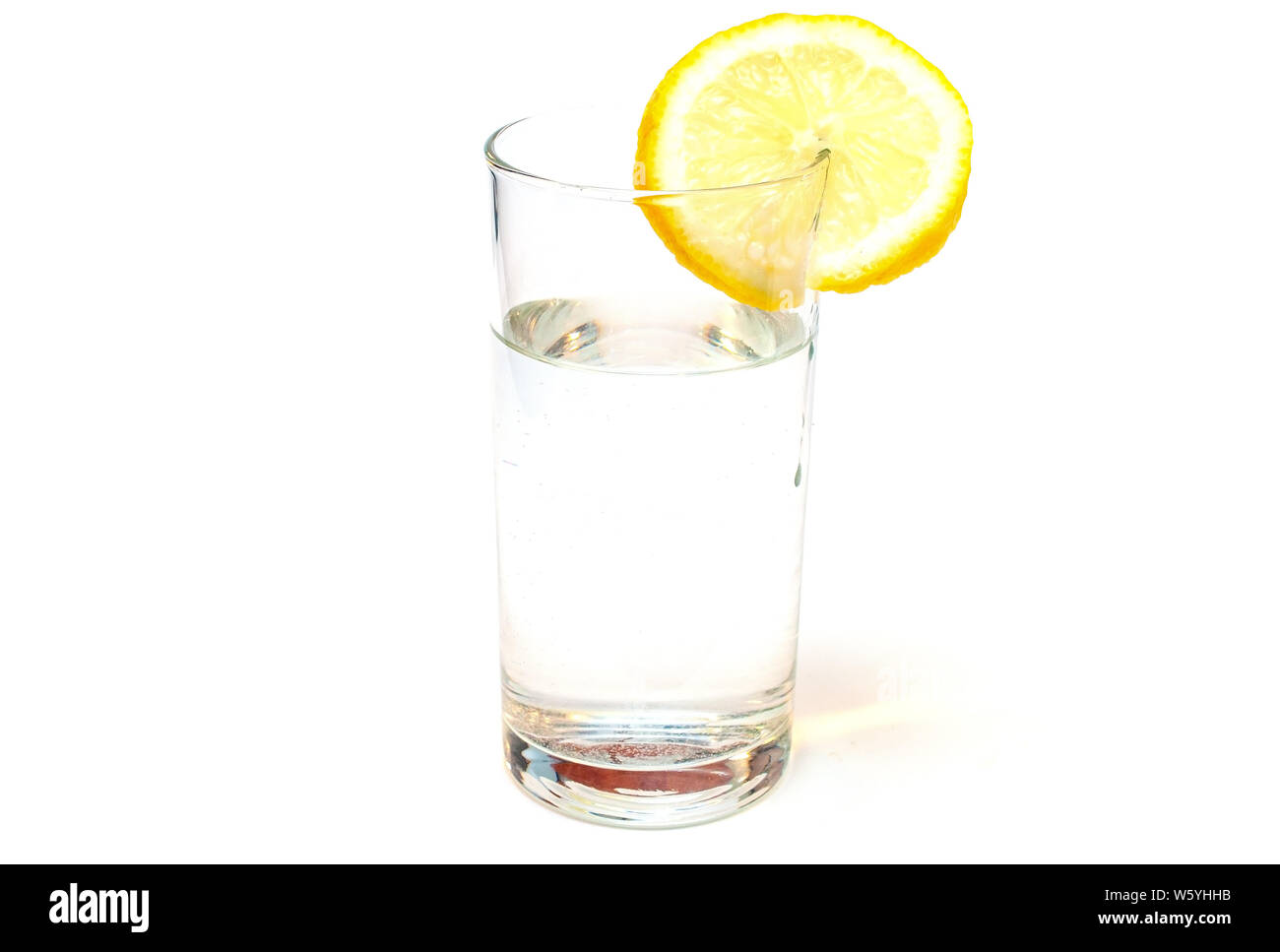 Glass of pure still water with lemon isolated on a white background ...