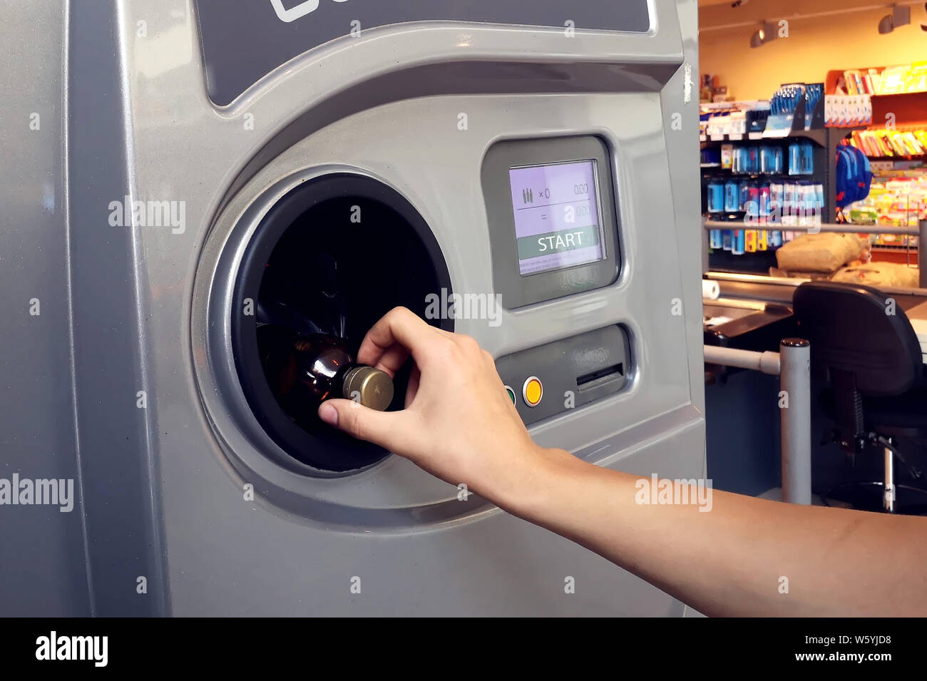 Man returns bottles and cans of reusable packagings in reverse vending ...