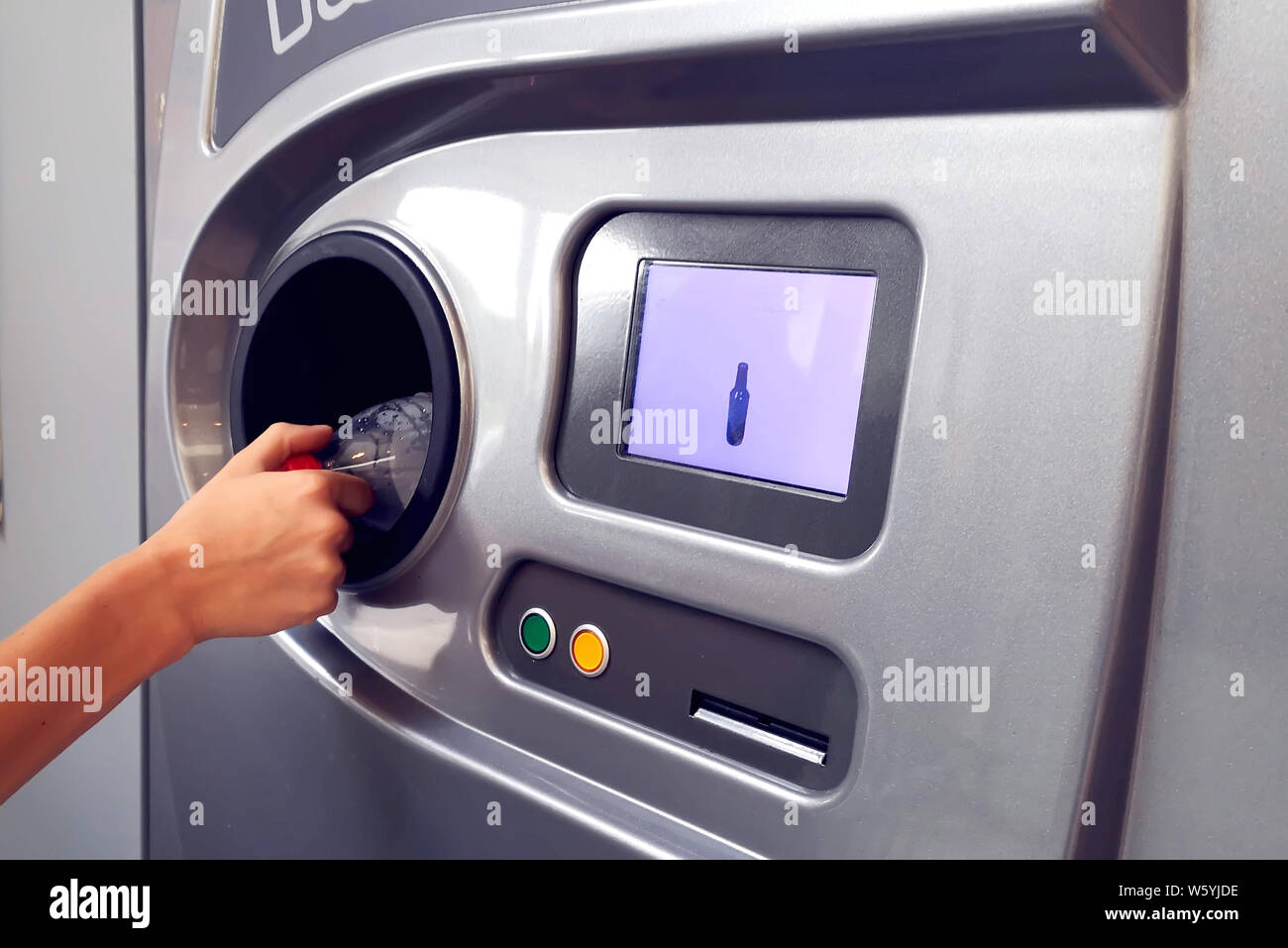 Man returns bottles and cans of reusable packagings in reverse vending ...