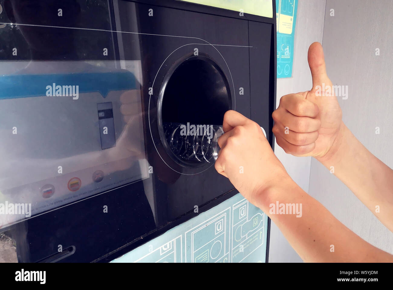 Man returns bottles and cans of reusable packagings in reverse vending ...