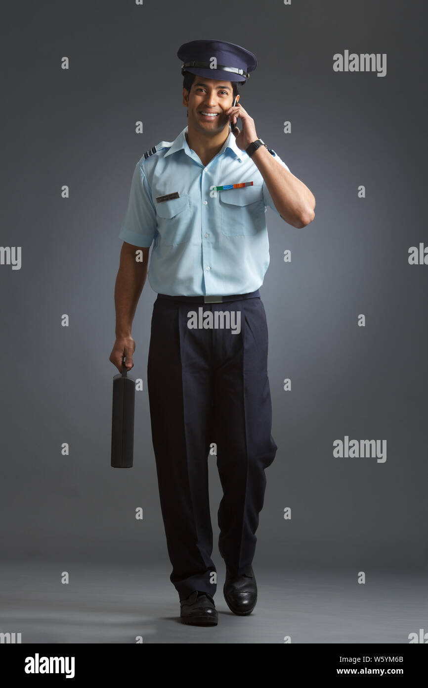 Airforce pilot talking on a mobile phone smiling Stock Photo - Alamy