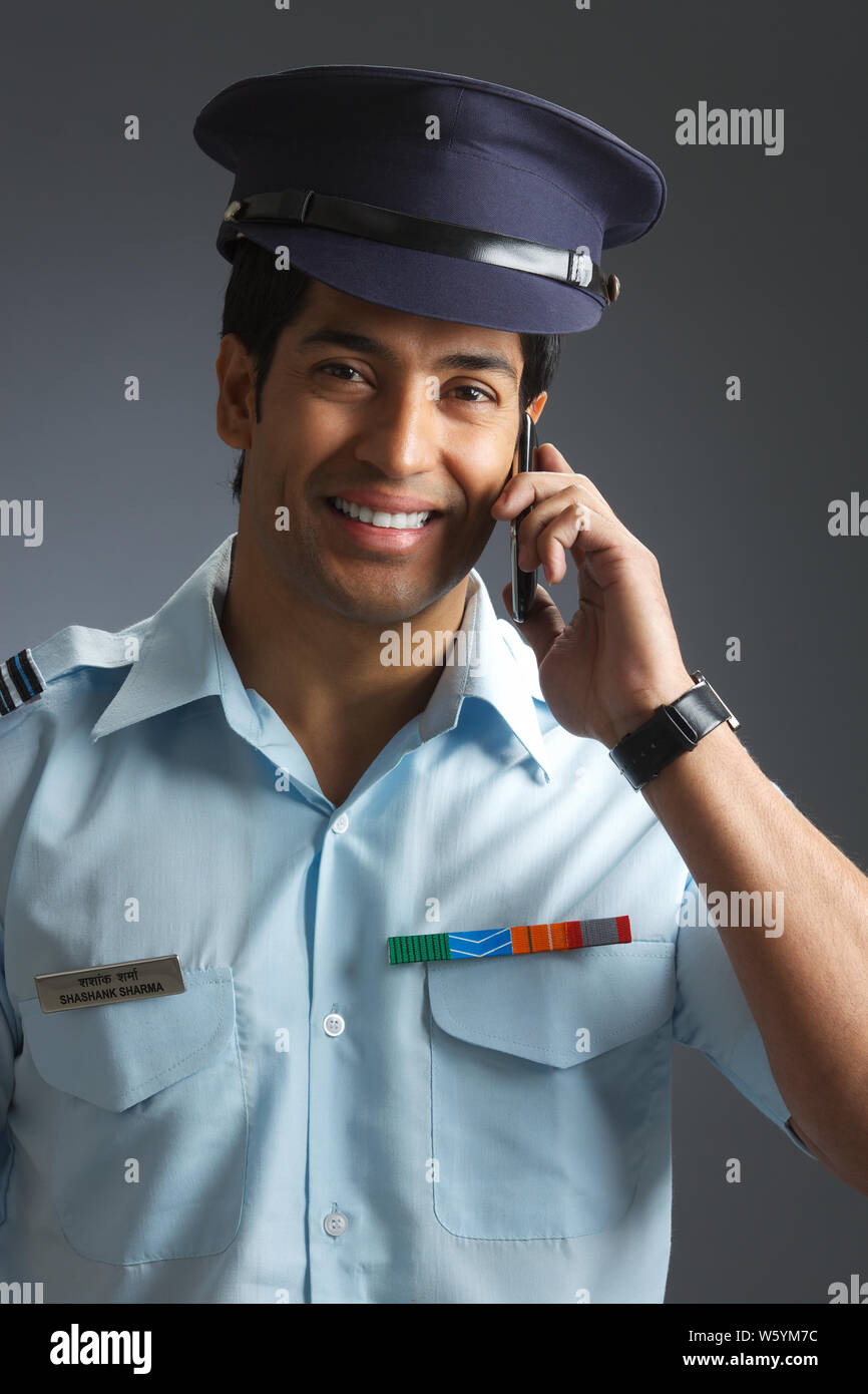 Airforce pilot talking on a mobile phone smiling Stock Photo - Alamy