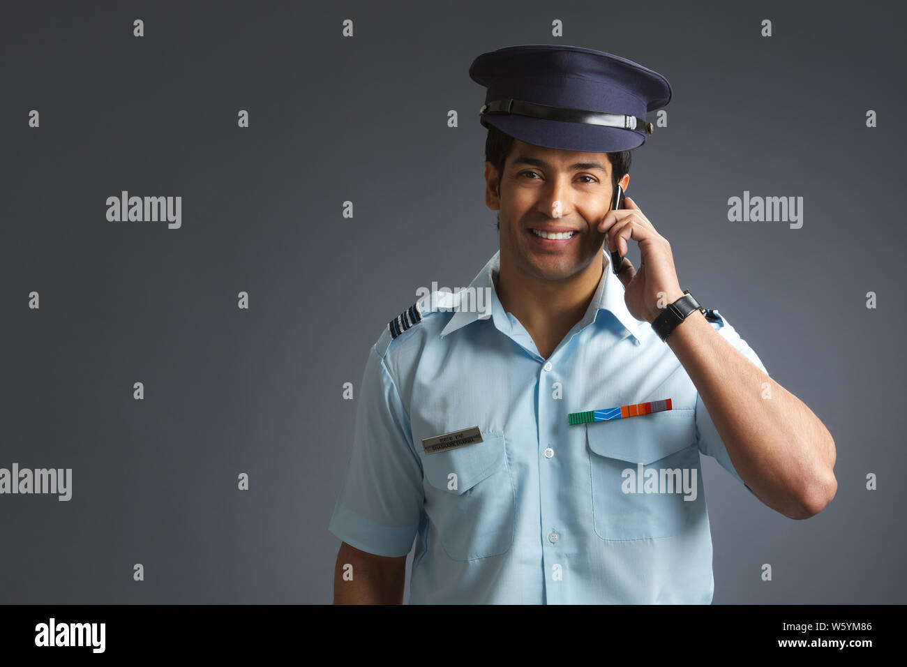 Airforce pilot talking on a mobile phone smiling Stock Photo - Alamy