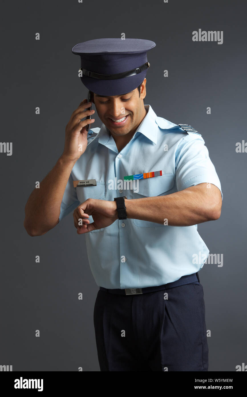 Airforce pilot talking on a mobile phone smiling Stock Photo - Alamy
