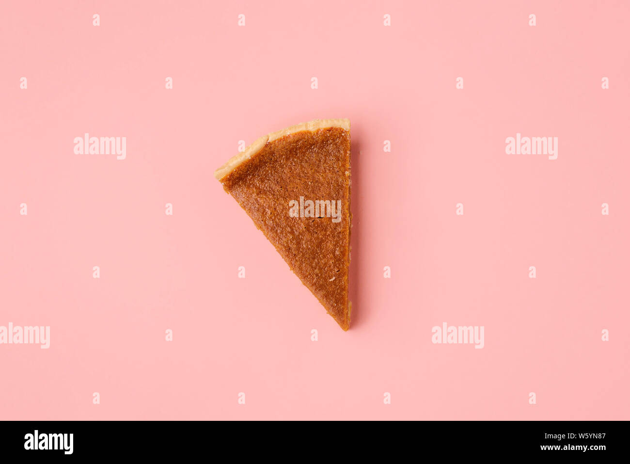 Traditional pumpkin pie slice on pink paper background. Above view of ...