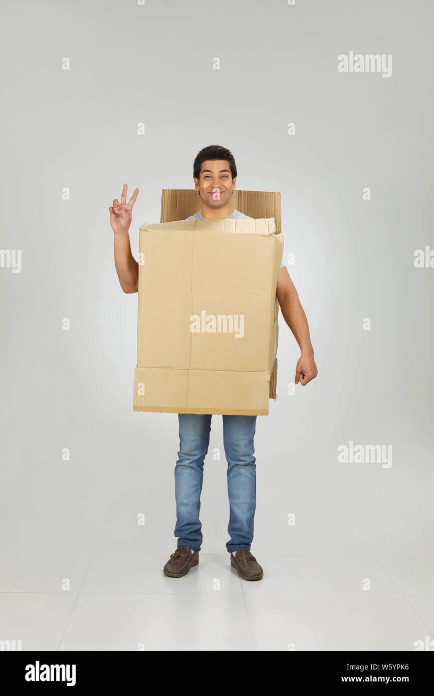 Man wearing cardboard box showing v sign Stock Photo - Alamy