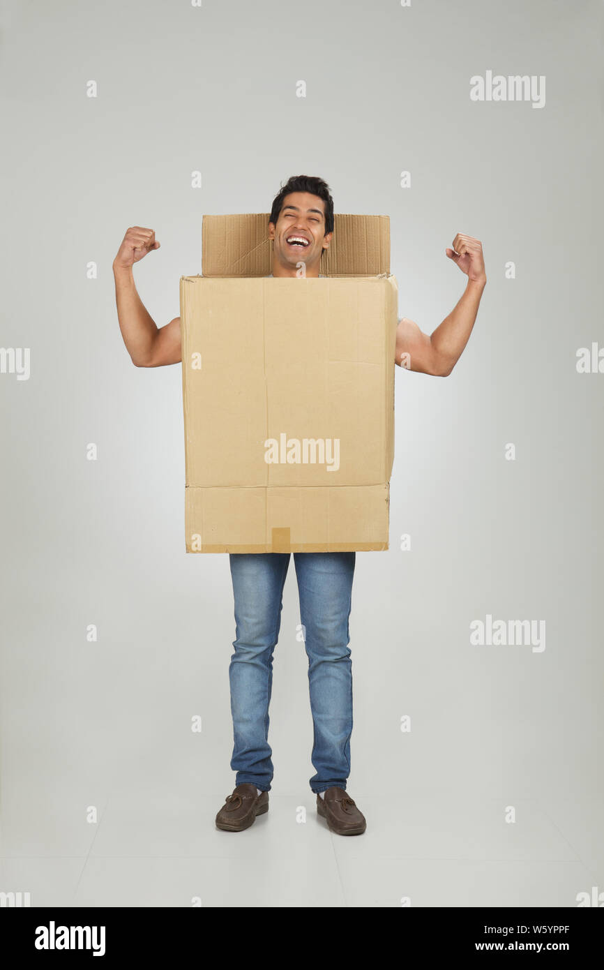 Man wearing cardboard box flexing muscles Stock Photo - Alamy