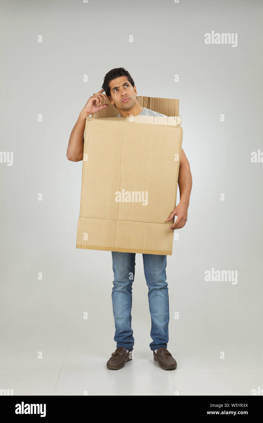 Man wearing cardboard box thinking Stock Photo - Alamy