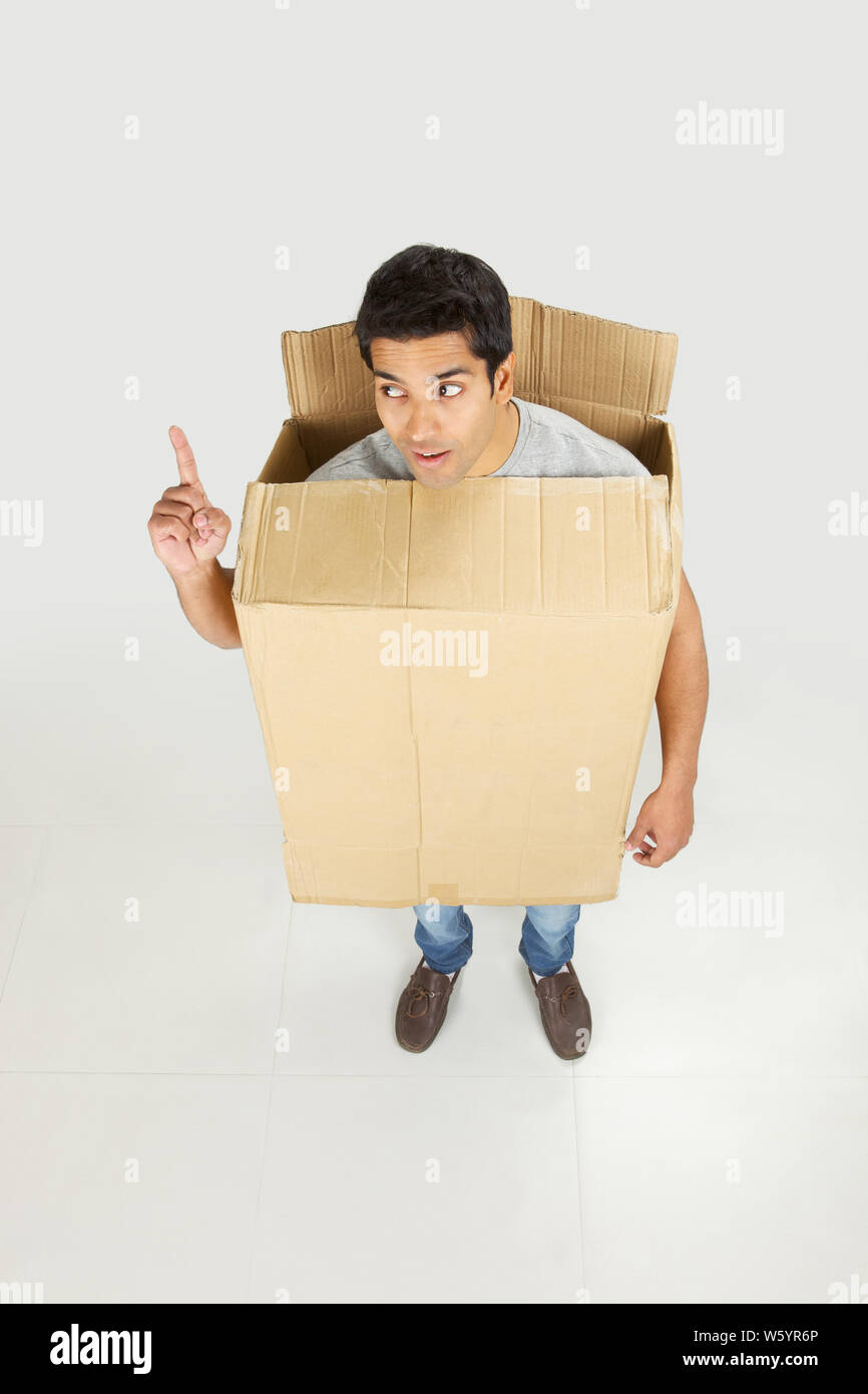 Man wearing cardboard box pointing upward Stock Photo - Alamy