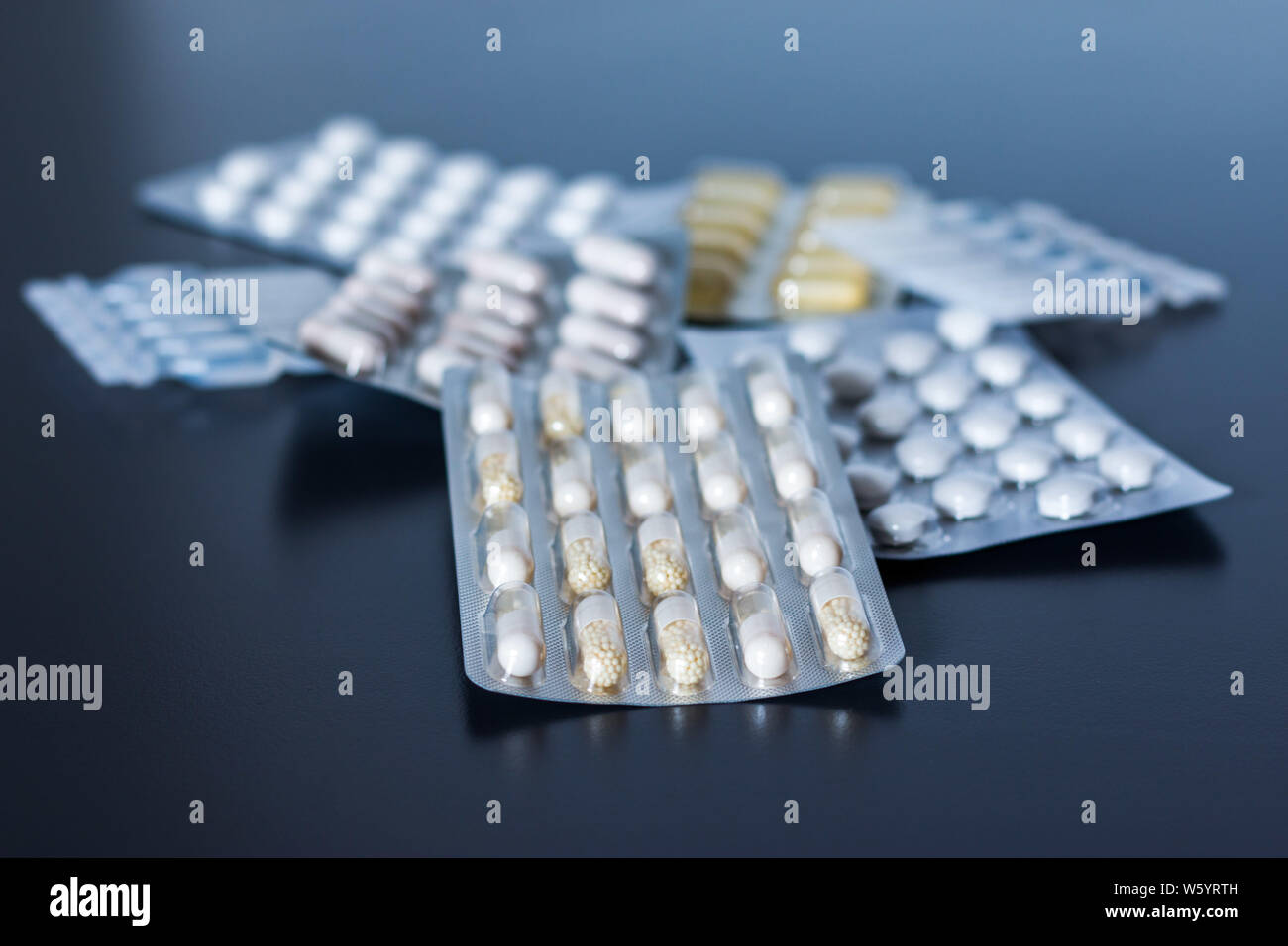 Pills or medicine lying on the grey table, drug abuse Stock Photo - Alamy