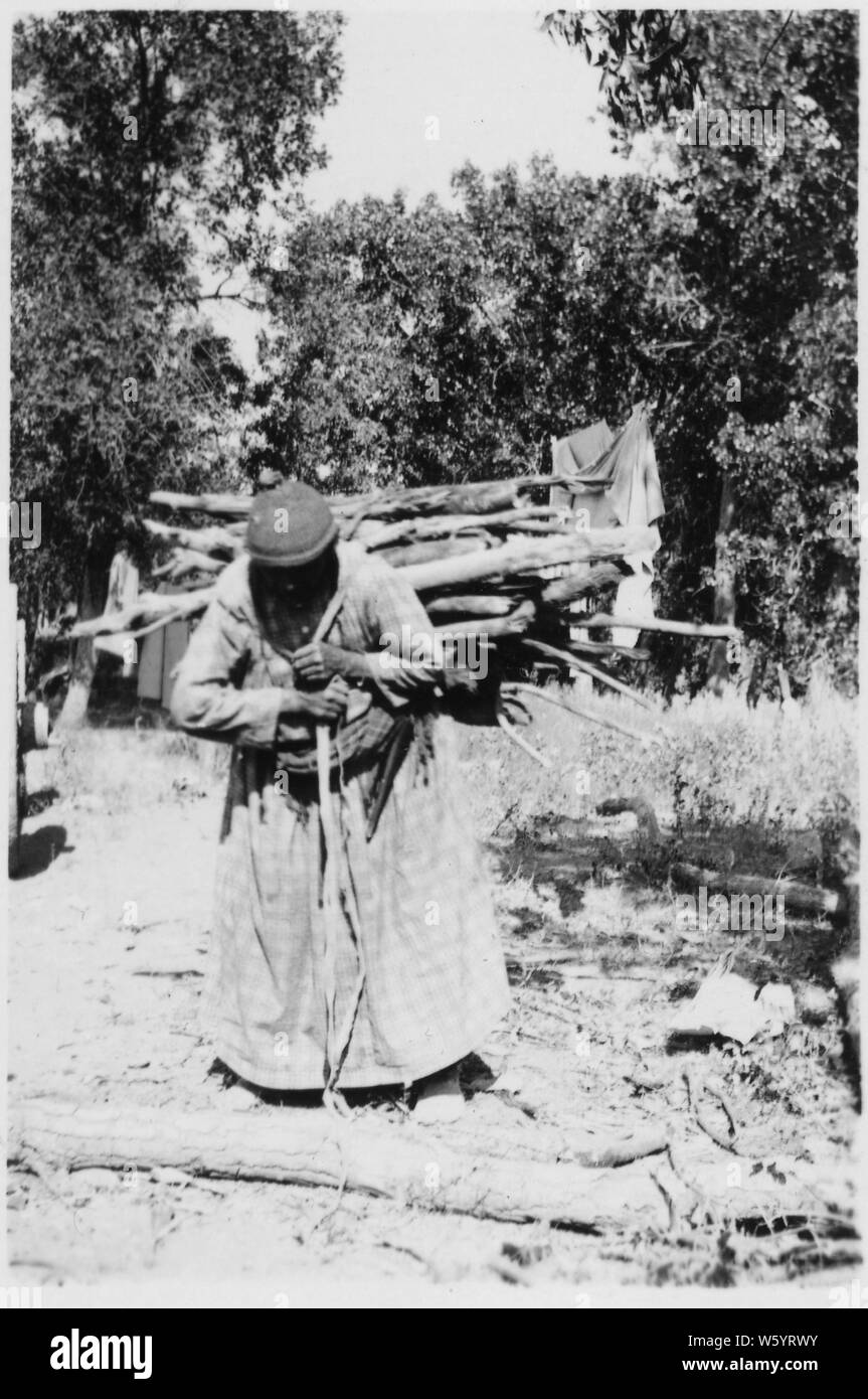 Woman prepares to carry a large log Stock Photo - Alamy