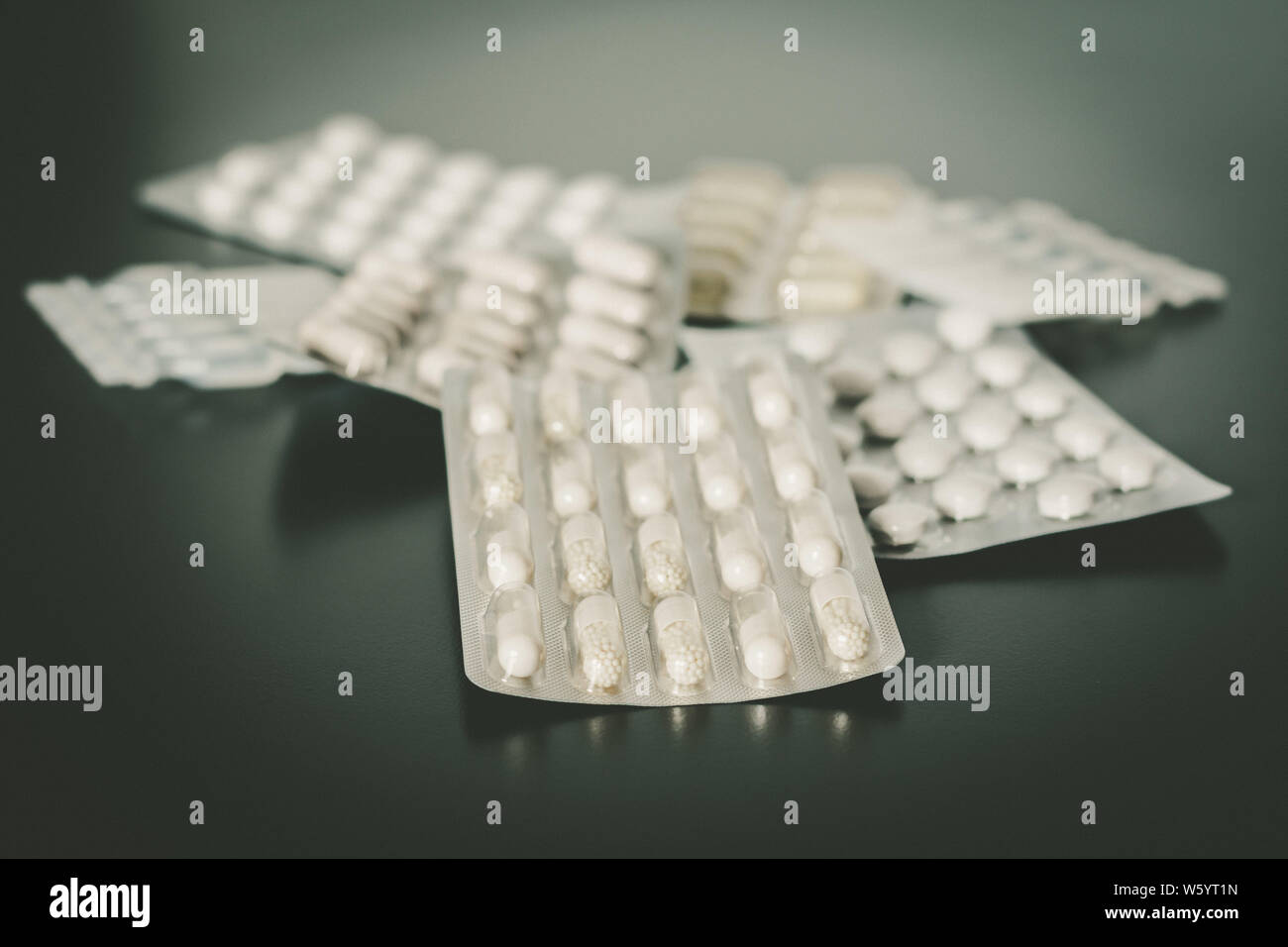 Pills or medicine lying on the grey table, drug abuse Stock Photo - Alamy