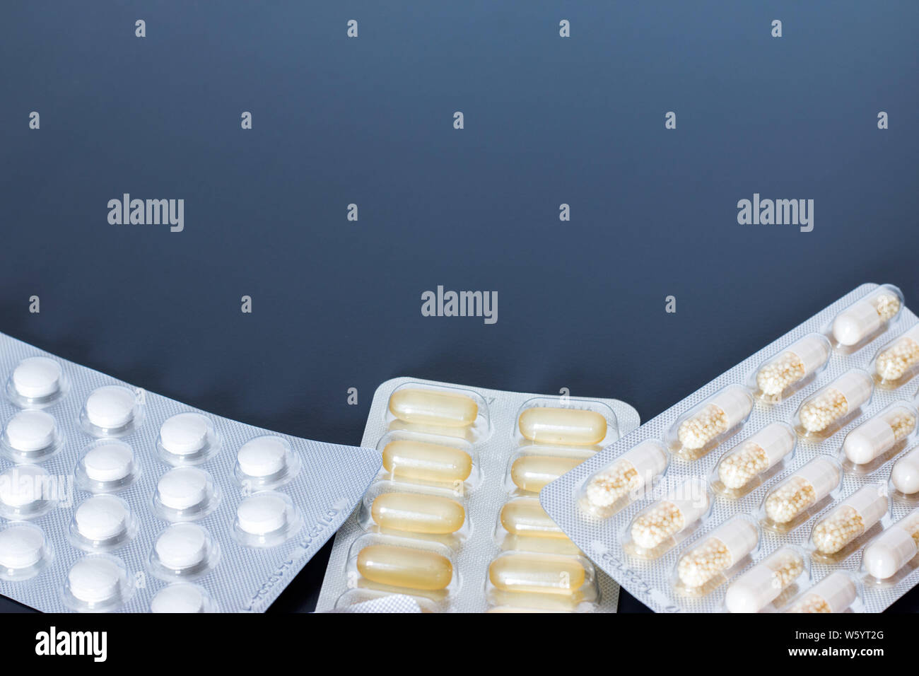 Pills or medicine lying on the grey table, drug abuse Stock Photo - Alamy