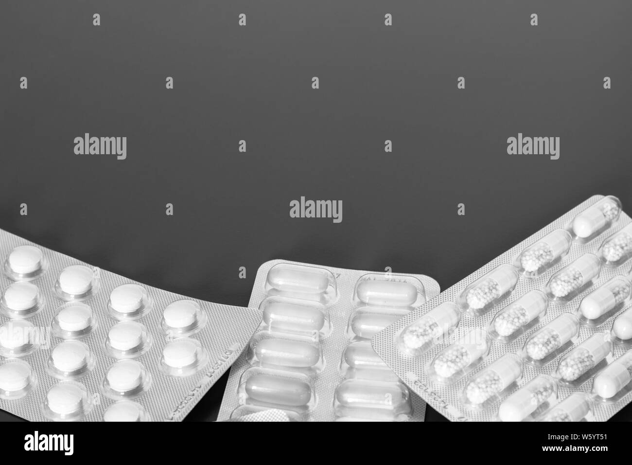 Pills or medicine lying on the grey table, drug abuse Stock Photo - Alamy