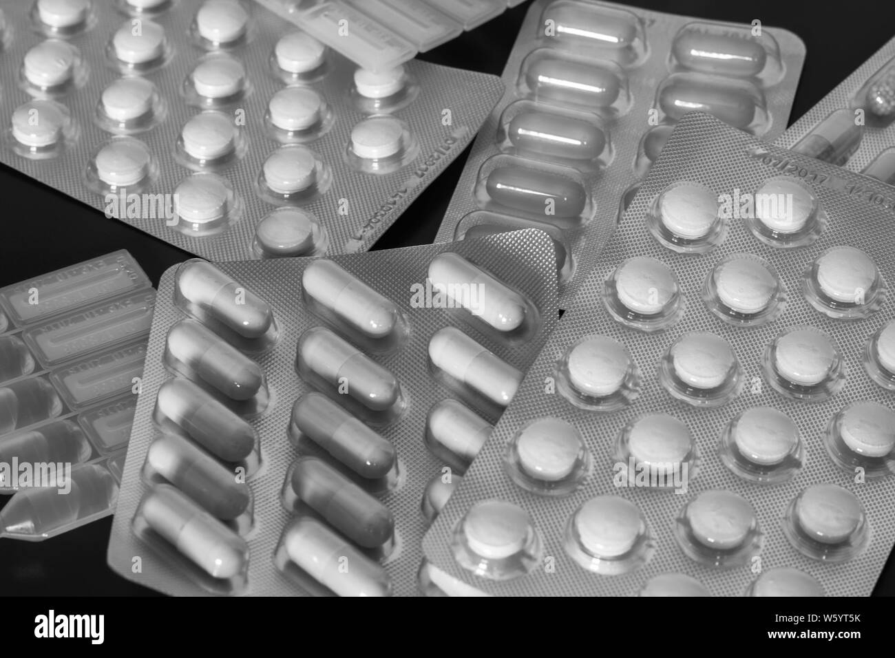 Pills or medicine lying on the grey table, drug abuse Stock Photo - Alamy