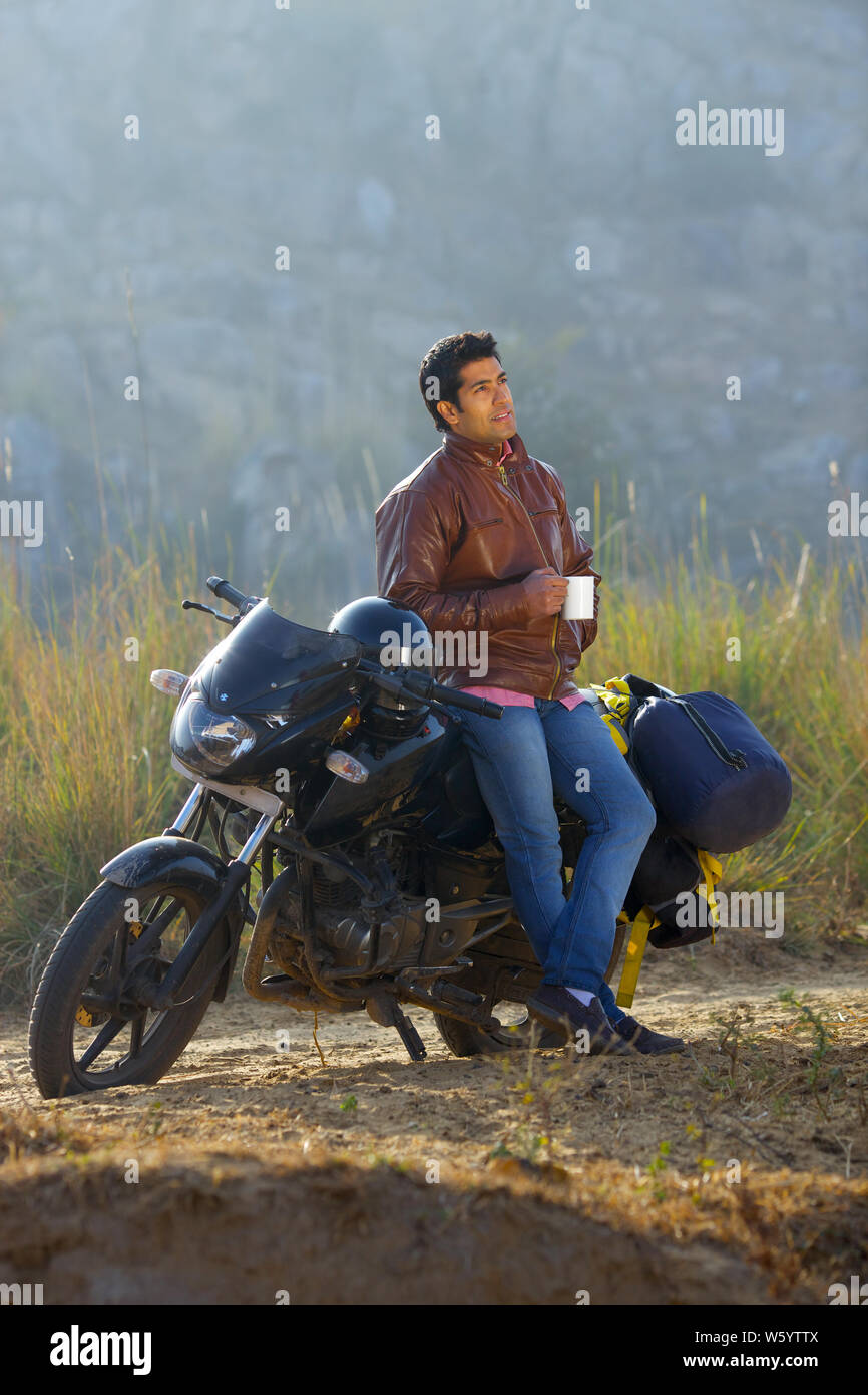 Man having tea on a motorcycle Stock Photo - Alamy