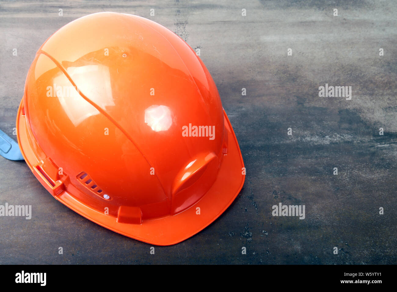 Orange safety engineer helmet on brown background Stock Photo - Alamy