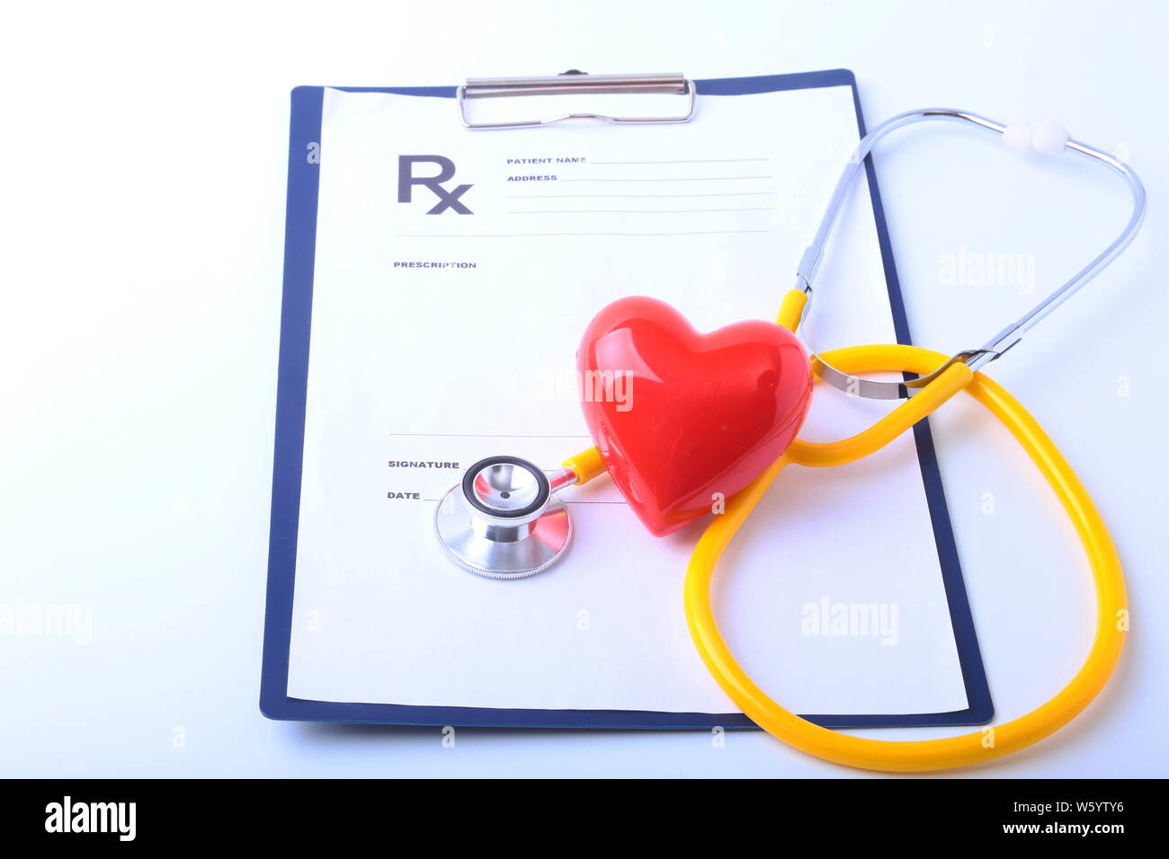 Closeup of medical stethoscope on a rx prescription, red heart isolated ...