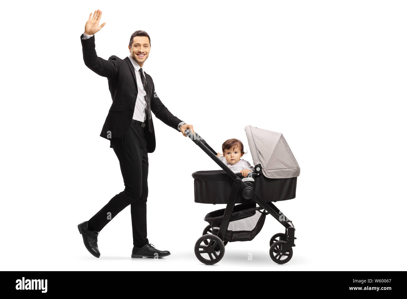 Businessman father in a suit pushing a buggy with a baby and waving ...