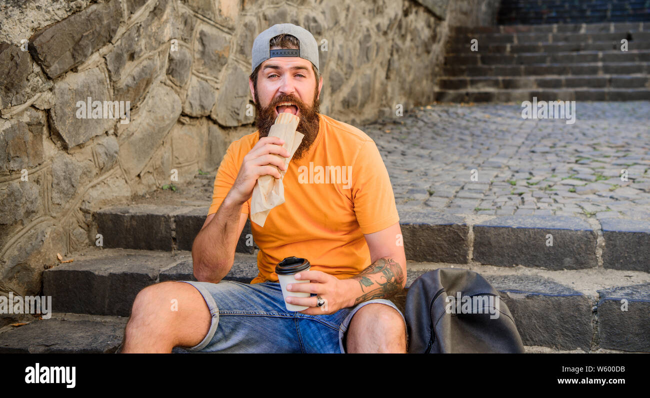 Man bearded enjoy quick snack and drink paper cup. Street food so good ...