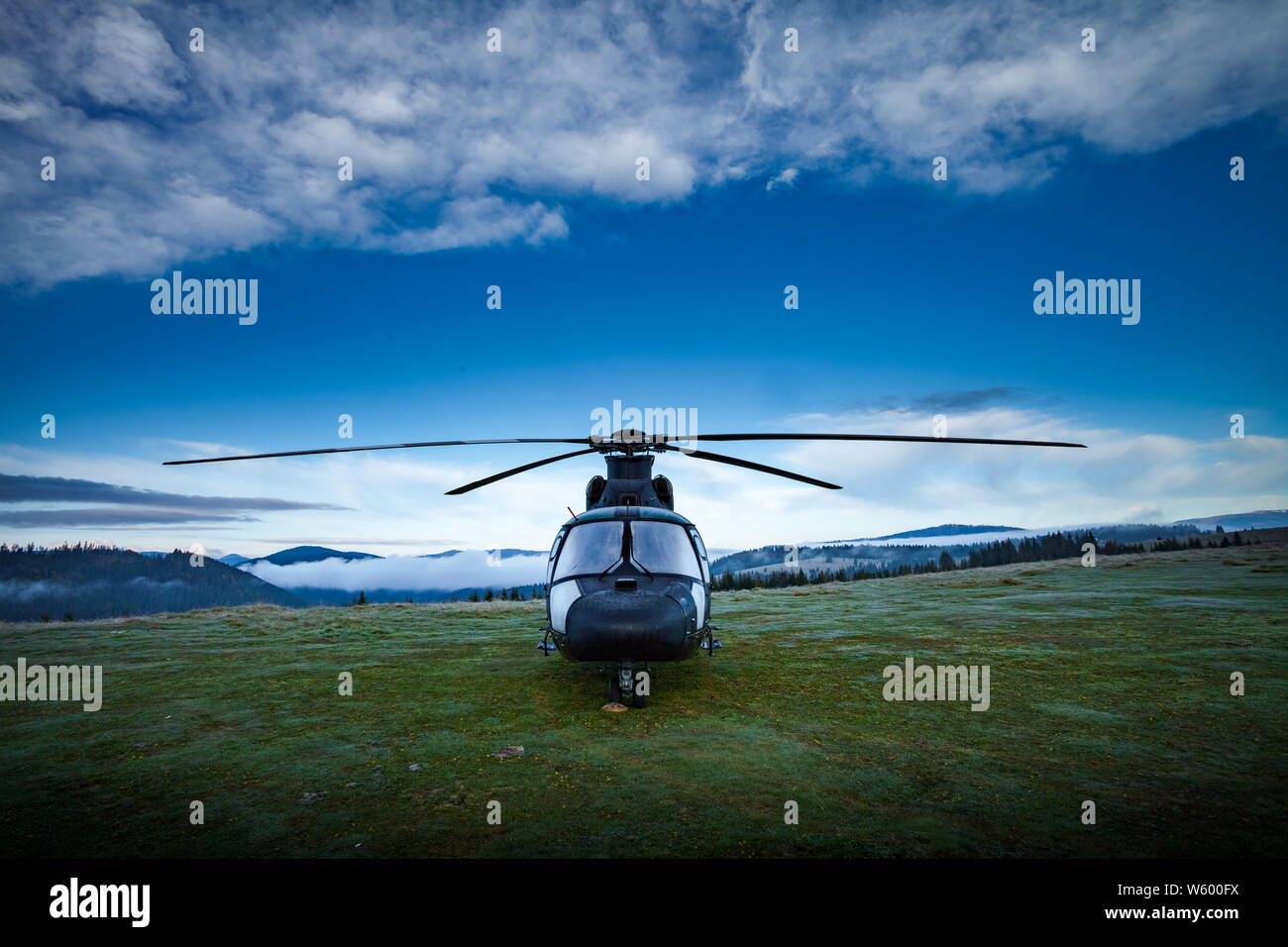 Back private helicopter in mountain landscape Stock Photo - Alamy